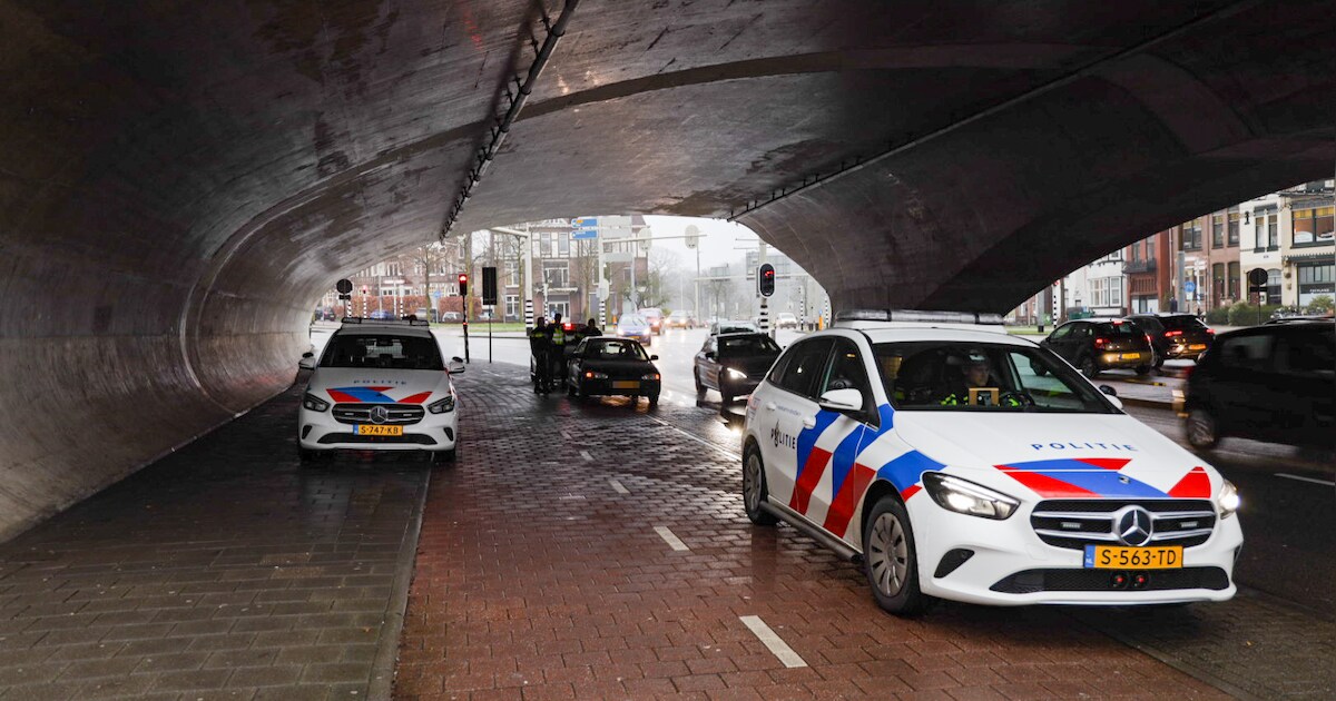 Auto klemgereden door politiewagens in Arnhems centrum, persoon ...